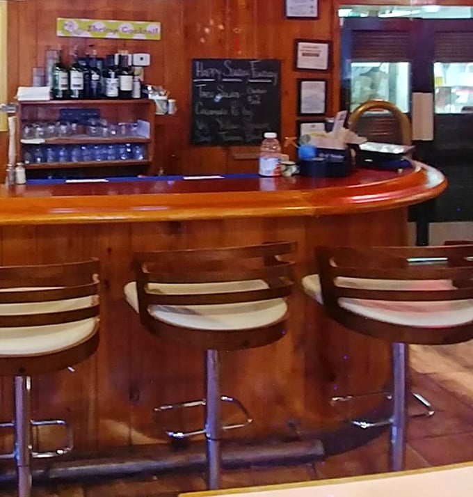 That curved wooden bar isn't just functional&mdash;it's where strangers become friends over cold drinks and hot seafood tips.