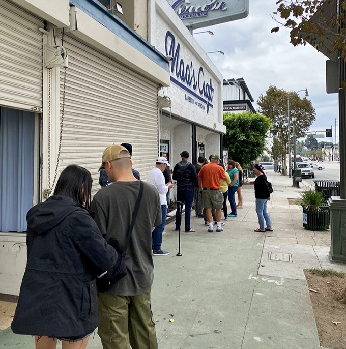 The line forms early when smoke signals announce brisket is ready. These patient pilgrims know that good things come to those who wait.