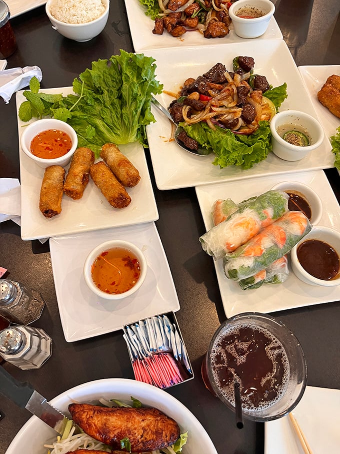 The full dine-in spread: egg rolls, spring rolls, bo luc lac, and fried fish proving variety really is delicious.