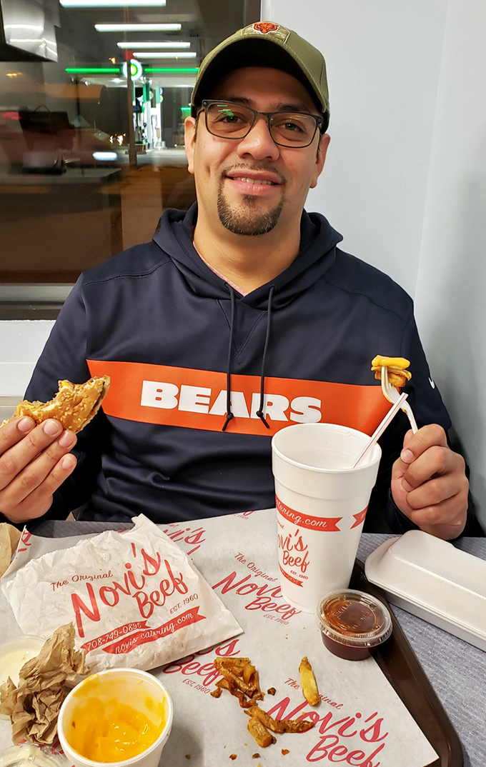 A satisfied customer shows off his Novi's feast, sporting Chicago Bears gear&mdash;because local loyalty extends from stadium to sandwich shop.