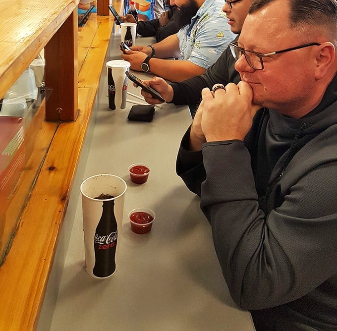 The universal posture of anticipation&mdash;hunched slightly forward, focused entirely on the imminent arrival of sandwich perfection.