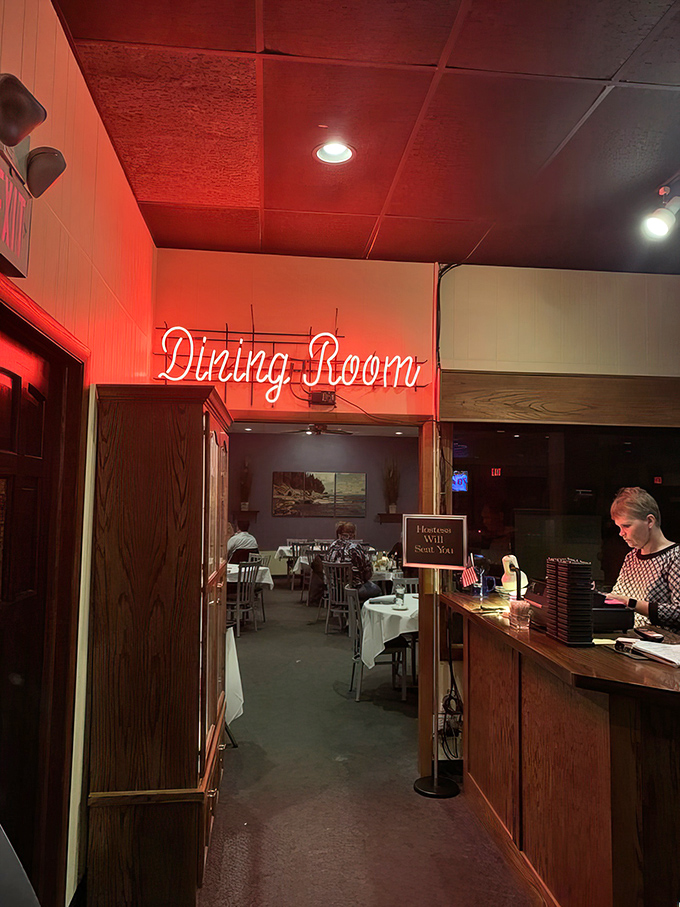 The neon "Dining Room" sign glows like a warm invitation. Follow the light to culinary satisfaction.