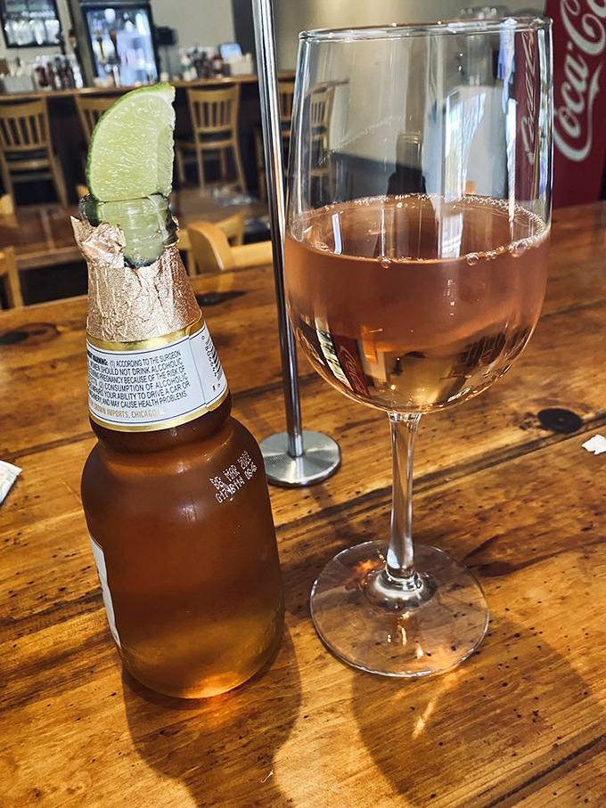 A cold beer with a lime wedge and glass of wine—because sometimes the perfect beverage pairing is whatever helps you slow down and savor the seafood moment.