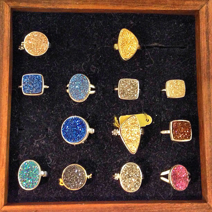 Druzy rings sparkle in their velvet nest, nature's crystalline masterpieces transformed into wearable geological wonders.