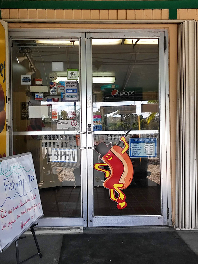 The entrance tells you everything&mdash;dancing hot dog character, business hours, and a whiteboard special. No pretense, just promises of deliciousness within.