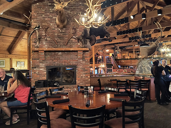 Stone fireplace and mounted wildlife giving off serious lodge vibes, minus the mosquitoes and hiking.