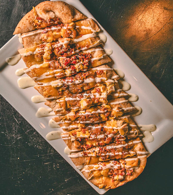 The flatbread arrives looking like an edible art project, with toppings arranged so perfectly you almost feel bad about destroying it. Almost.
