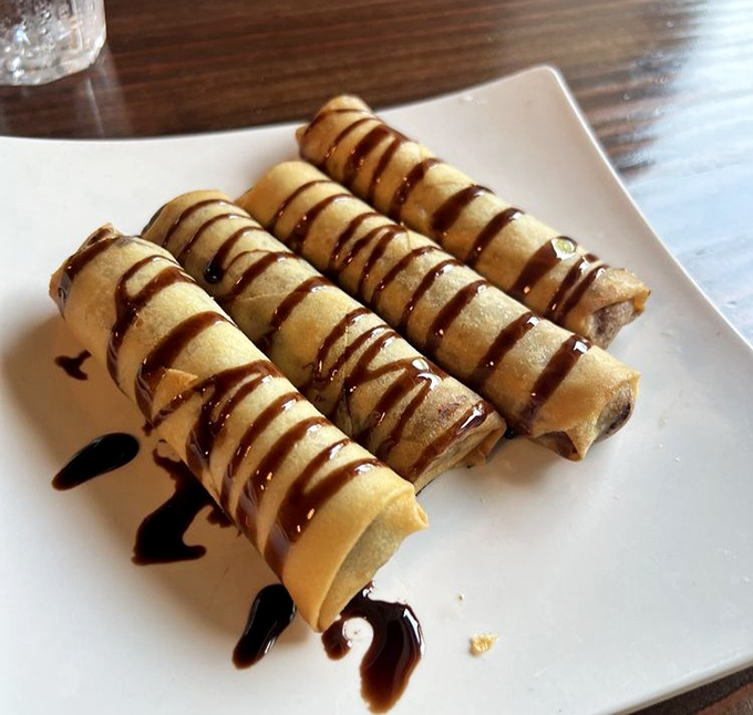 Dessert rolls drizzled with chocolate that would make Willy Wonka jealous. These sweet cylinders prove that bananas reach their highest purpose when fried.