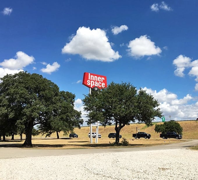 The retro roadside sign stands as a beacon for curious travelers, promising subterranean adventures just off Interstate 35.