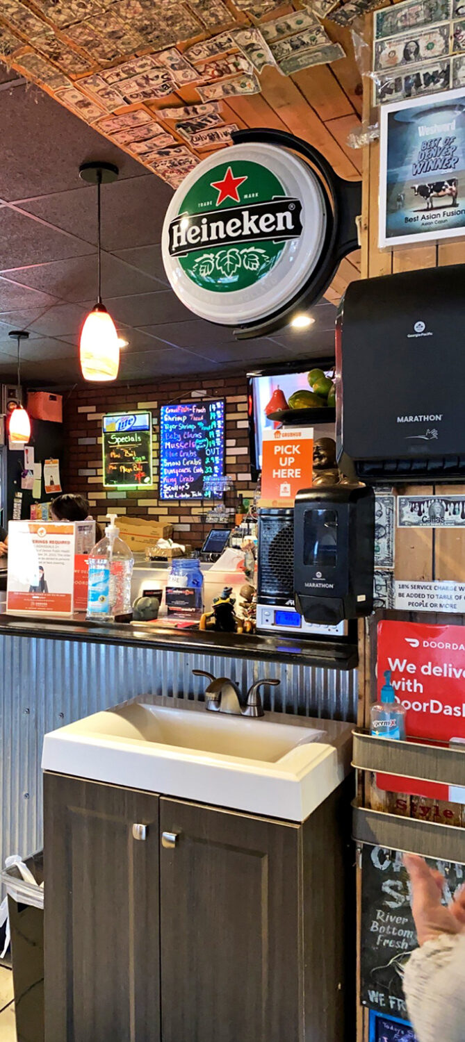 Dollar bills and beer signs create that "been here forever" vibe. The decor says, "We're serious about seafood, not interior design."