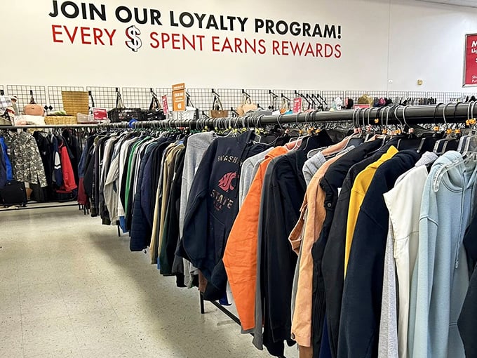The clothing section stretches toward retail infinity, with college sweatshirts and professional attire hanging together in democratic fashion equality.