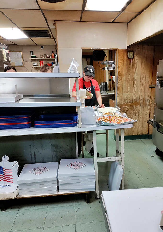 Behind-the-scenes pizza creation in action, where skilled hands transform simple ingredients into edible art.
