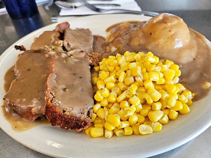 Meatloaf and mashed potatoes swimming in gravy with a side of sunshine-yellow corn. Comfort food that whispers, "Take the afternoon nap. You've earned it."