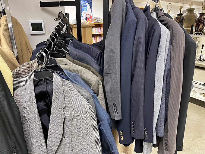 Men's suits hang with dignity, each silently whispering, "I could make you look like a million bucks for about twenty."