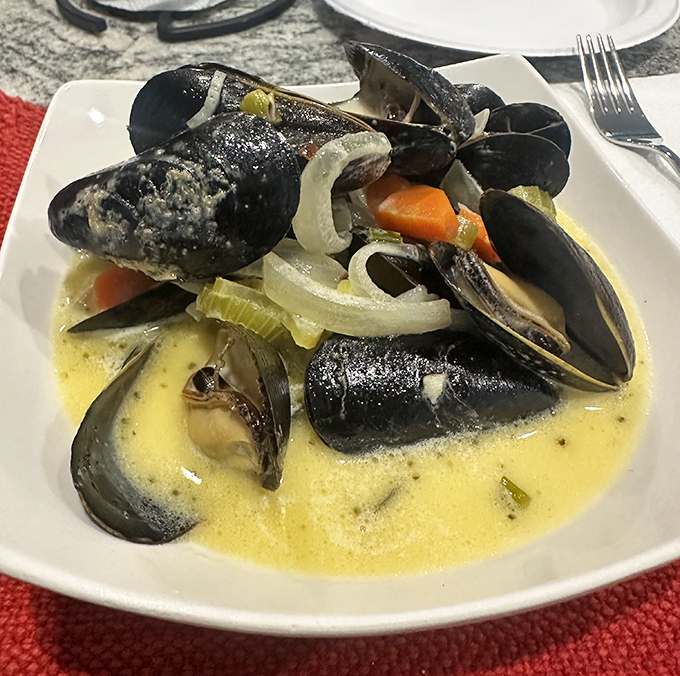 These mussels swimming in buttery broth aren't just shellfish—they're little black submarines delivering payloads of oceanic flavor straight to your taste buds.
