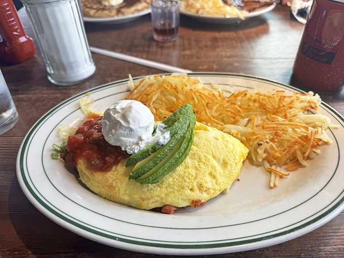 An omelet that's achieved fluffy perfection, topped with salsa and accompanied by hash browns that crackle with each bite.