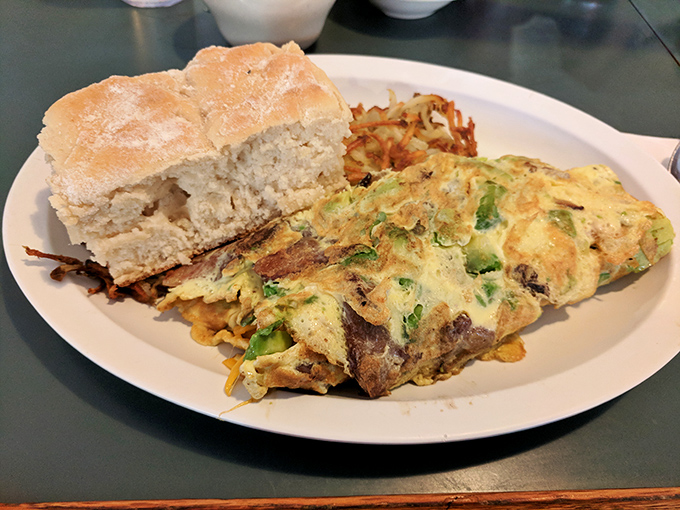 This isn't just an omelet; it's a vegetable treasure chest wrapped in perfectly cooked eggs. The biscuit stands by, ready for gravy-sopping duty.