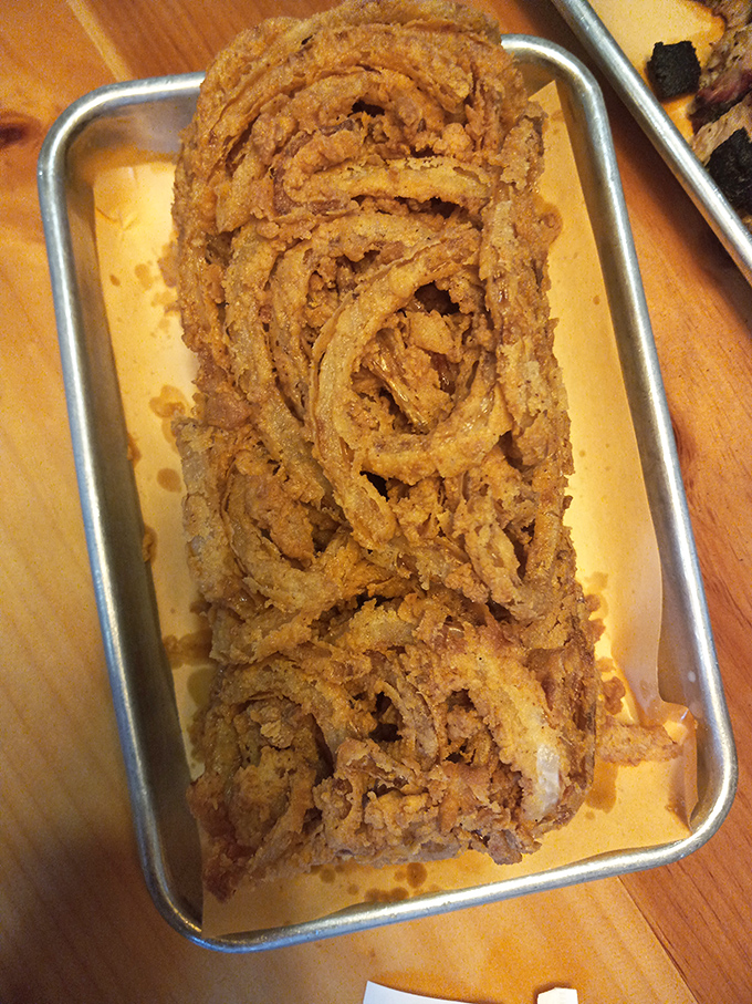 Onion rings stacked higher than your weekend ambitions – golden, crispy circles of joy that deserve their own spotlight.