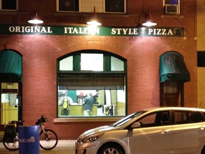 Evening glow illuminates pizza paradise. The green awnings and warm light beckon hungry travelers like a culinary lighthouse.