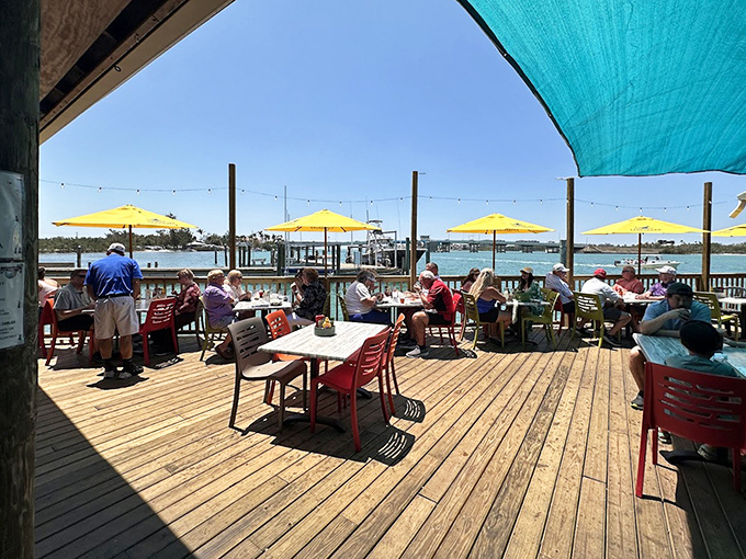 Waterfront dining with yellow umbrellas where every seat offers a view worth more than the meal itself.