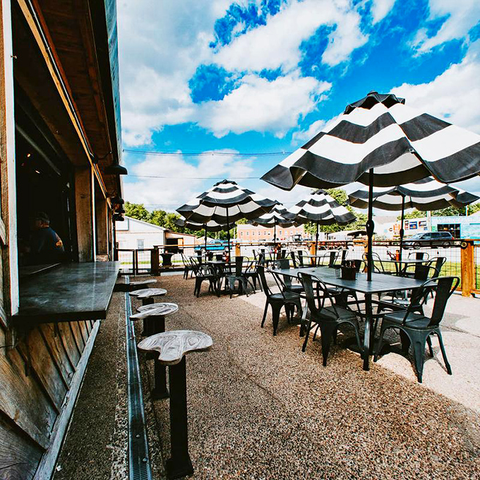 Black and white striped umbrellas create an outdoor oasis for enjoying smoky treasures. Blue Kentucky skies included at no extra charge.