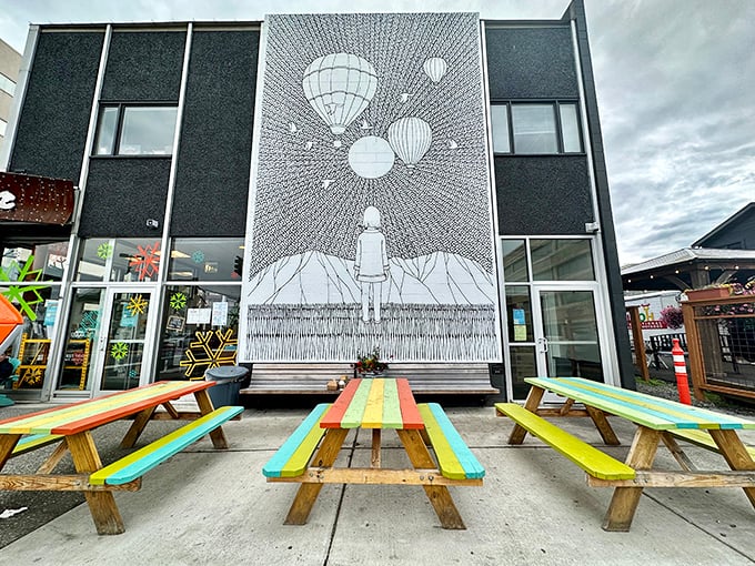 Colorful picnic tables outside showcase Alaskan practicality&mdash;when the sun shines, dining al fresco beneath that striking mural becomes part of the experience.