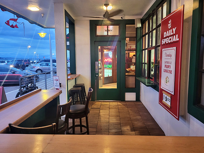 The entrance beckons with its casual coastal charm &ndash; a prelude to the seafood treasures waiting just beyond those green-trimmed doors.