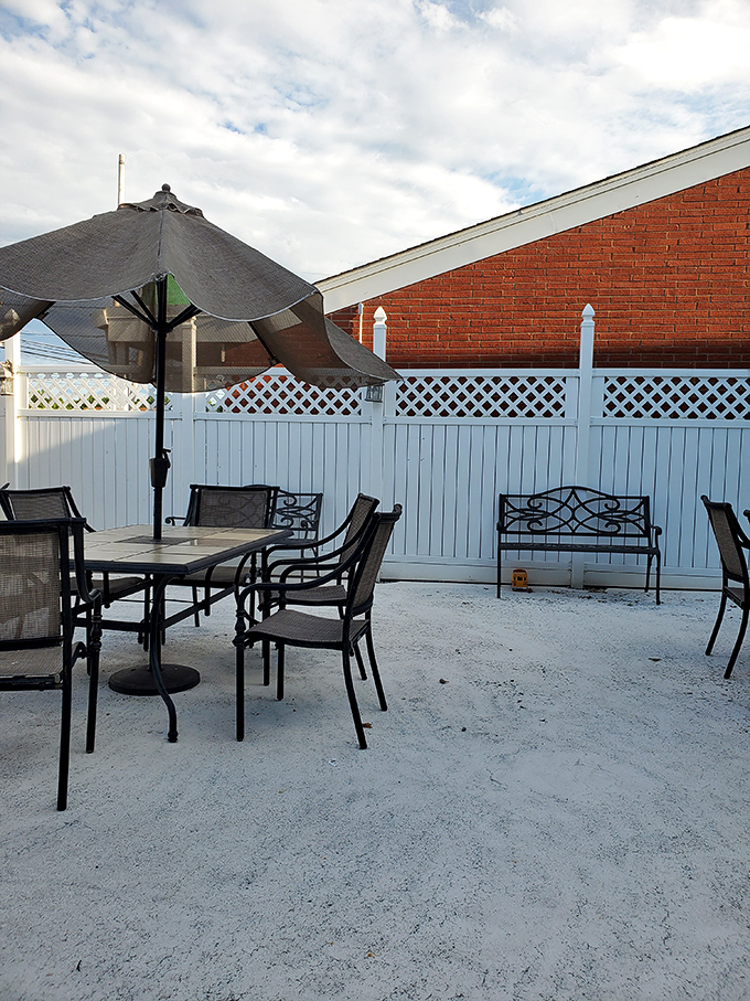 Outdoor seating area where summer evenings become magical. Simple tables, umbrellas, and the promise of al fresco Italian dining.