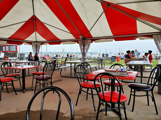 Al fresco dining under red and white canopies, where the sea breeze enhances every bite. No sound system needed when you have lapping waves.