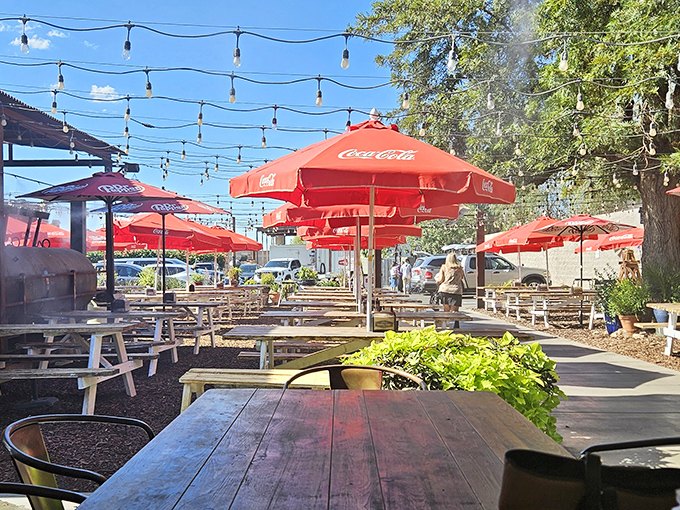 The outdoor dining area, where string lights twinkle above and the aroma of smoked meats mingles with Arizona's perfect evening air.