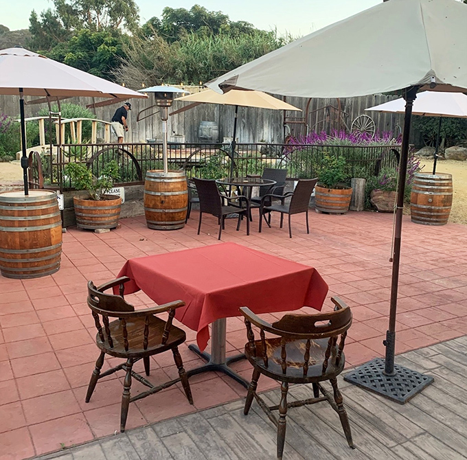 The outdoor patio offers a peaceful retreat with wine barrel accents, where Central Coast breezes complement your meal under umbrella-shaded tables.