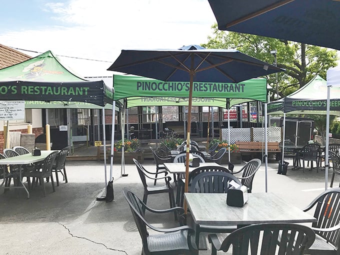 Outdoor dining under those green canopies feels like a block party where everyone's invited and pizza is the guest of honor.