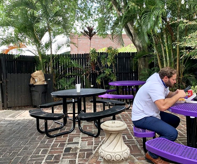 The outdoor patio offers a tropical respite where you can contemplate the profound relationship between purple tables and smoked meats.