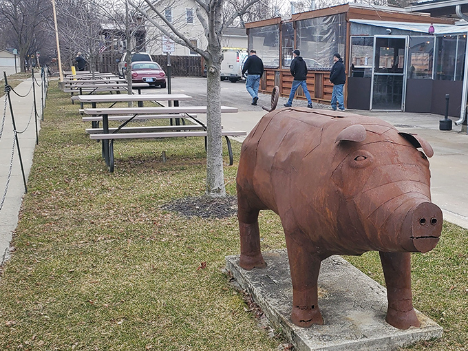 Outdoor picnic tables invite communal dining, while the watchful pig statue reminds you exactly why you've made this delicious pilgrimage.