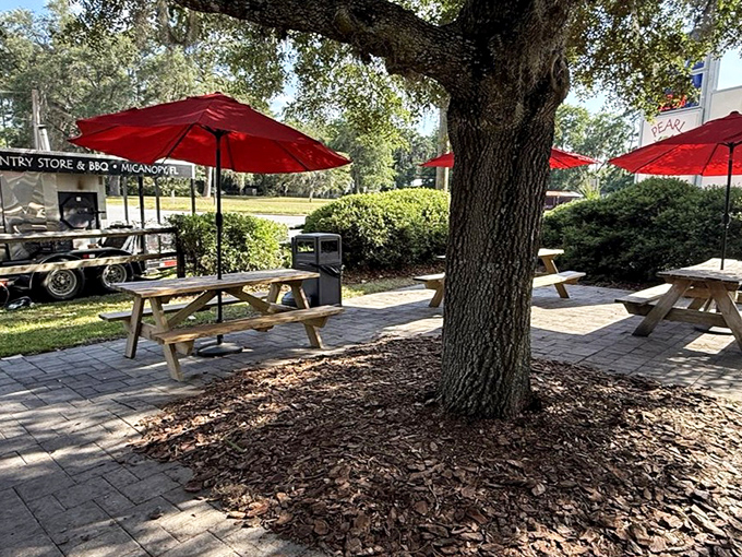 Outdoor seating under sprawling oaks offers a peaceful respite. Red umbrellas provide shade while you contemplate ordering seconds.
