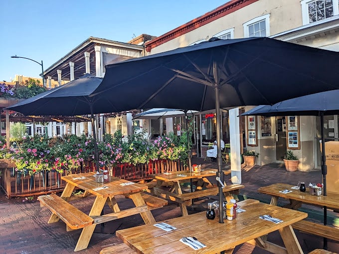 Outdoor dining under Santa Fe's famous blue skies, where wooden picnic tables and colorful flowers create the perfect lunch backdrop.