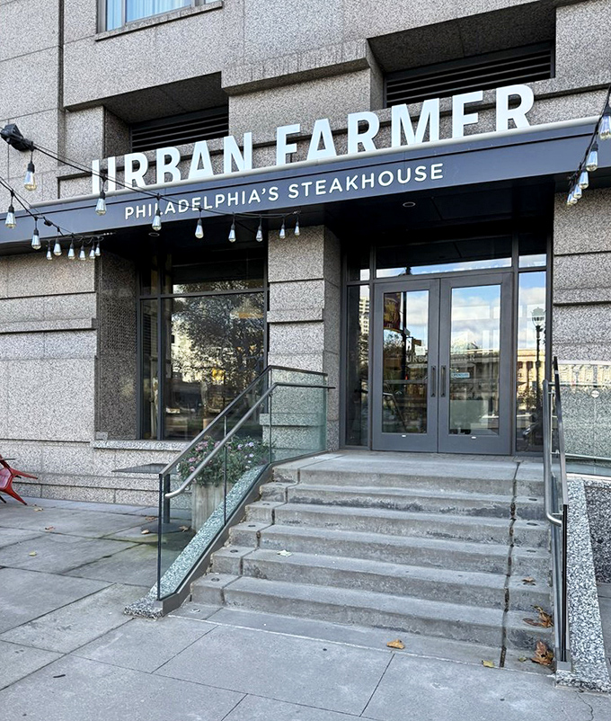 The entrance promises urban sophistication with a side of farmhouse values. Those string lights aren't just decoration&mdash;they're a welcome committee.