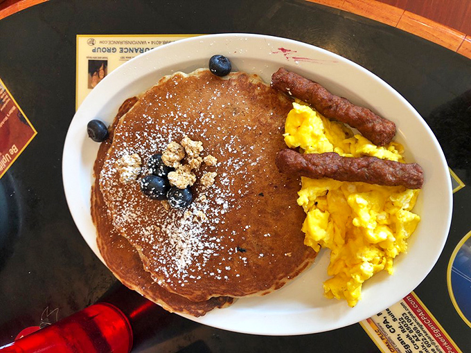 A pancake so large it has its own zip code, topped with blueberries that somehow make you feel virtuous about eating dessert for breakfast.