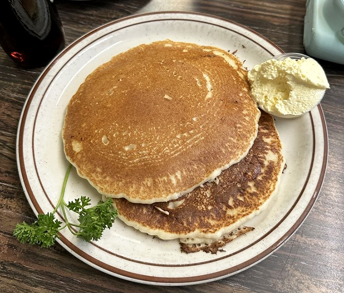 Pancakes stacked higher than your weekend plans, with butter melting down the sides like a delicious avalanche of breakfast bliss.