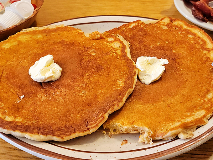 Pancakes so perfectly golden they belong in a breakfast hall of fame, with butter melting into their fluffy centers like a warm morning hug.