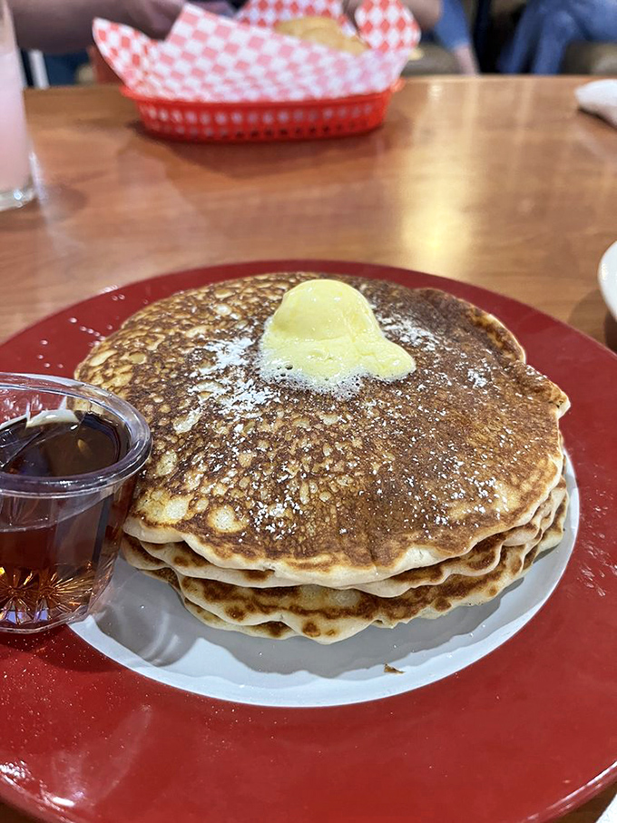 Pancakes stacked higher than my hopes on payday. That melting butter pat is performing a slow, beautiful swan dive. 