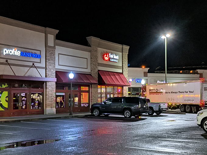 After dark, that red crab sign glows like a beacon for the seafood-starved. The wet pavement reflects promises of warm butter and cold drinks.
