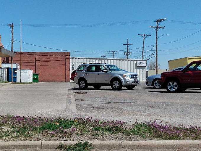 The humble parking lot—where vehicles wait patiently while their owners embark on thrifting adventures inside. No valet required.