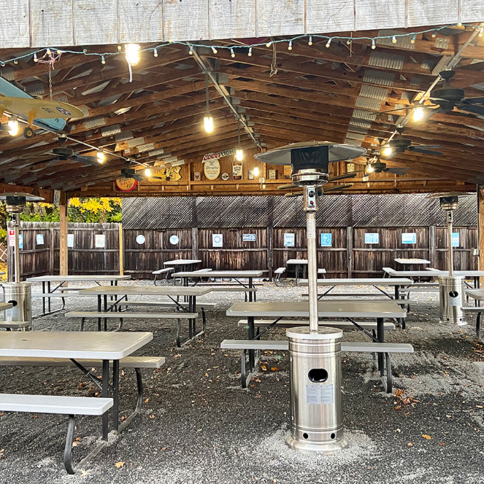 String lights illuminate the covered patio where picnic tables host gatherings that turn strangers into barbecue buddies.