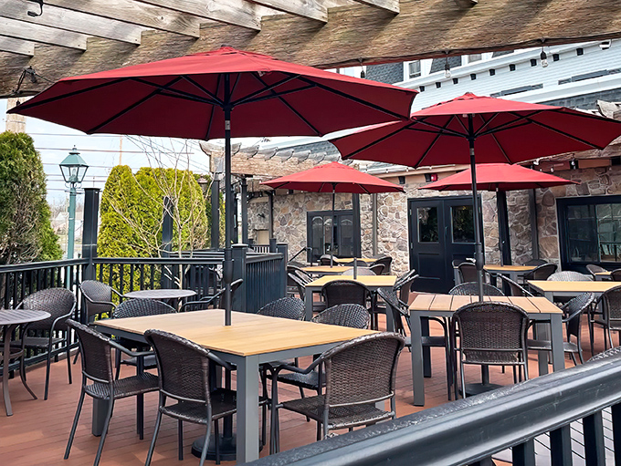 Red umbrellas stand sentinel over the patio tables, creating intimate dining islands where Pennsylvania weather becomes part of the ambiance rather than an obstacle.