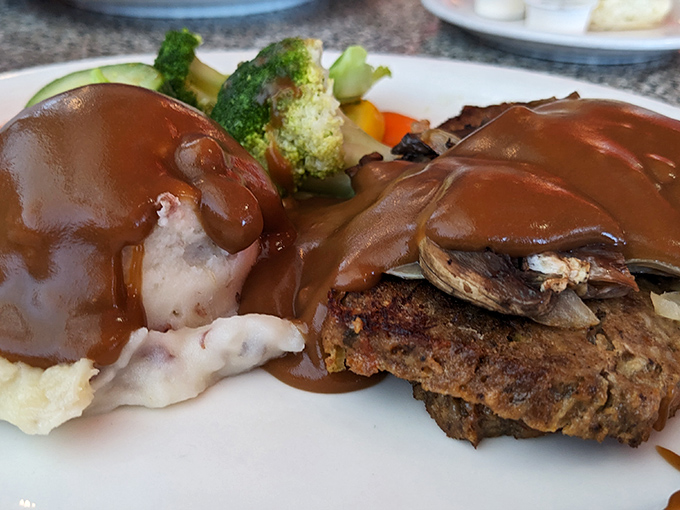 Comfort food that requires no translation. Rich gravy cascades over meatloaf and mashed potatoes like a brown waterfall of happiness.