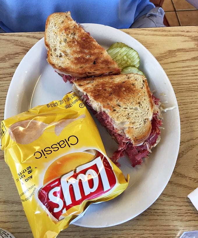 A proper Reuben sandwich that's piled so high with corned beef it needs structural engineering. Pickle on the side for moral support.