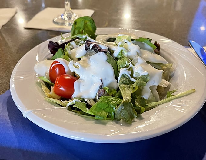 A garden salad that actually looks garden-fresh—crisp greens, bright tomatoes, and dressing that knows its supporting role.