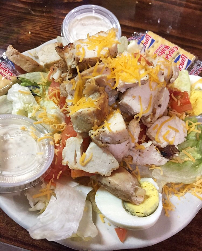 The salad arrives looking substantial enough to feed a small village, because even vegetables get supersized here.