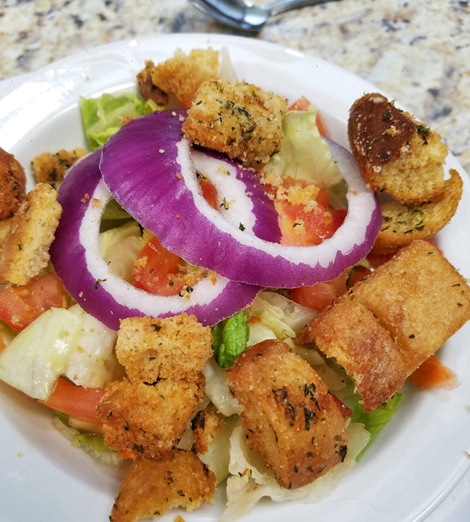 A salad that doesn't apologize for its croutons. Those purple onion rings add both color and conviction to a dish that's hardly an afterthought.